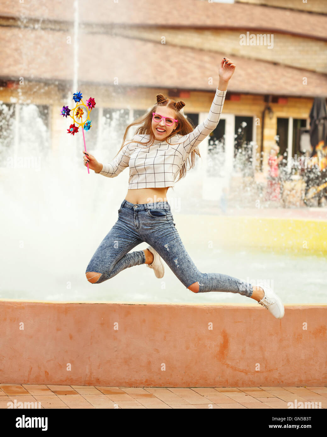 Lovely cheerful girl teenager jumping from a Spinner Array Tool. Summer ...