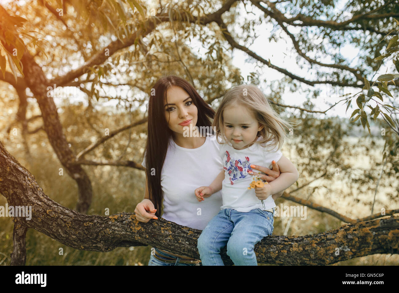 child near tree with mom Stock Photo - Alamy