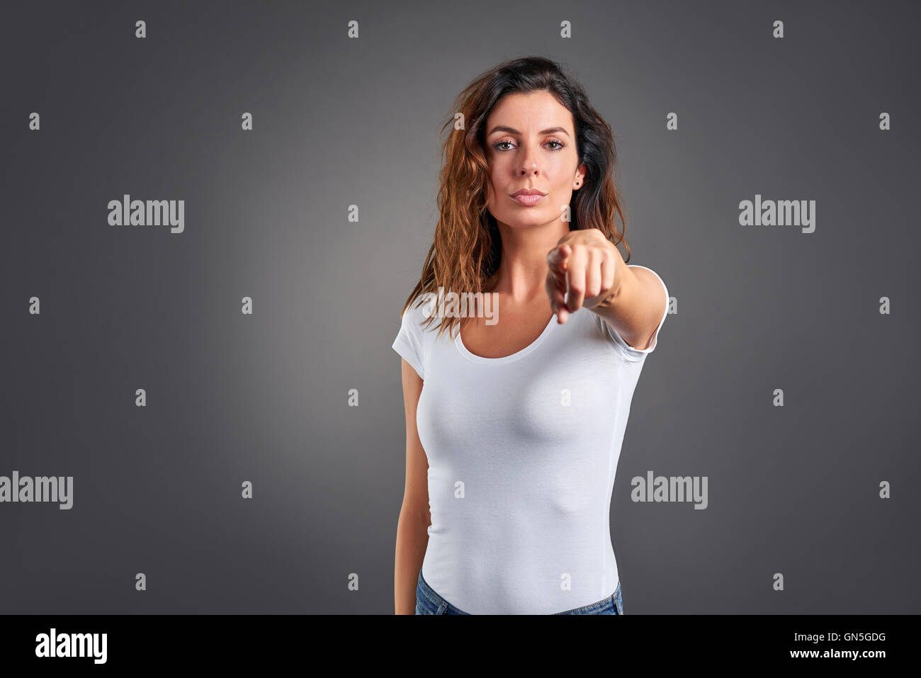 A serious young woman pointing in to the camera Stock Photo - Alamy
