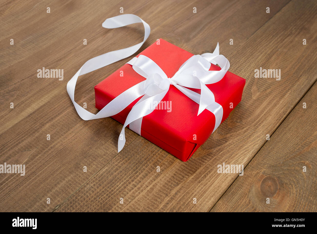 surprise in red packing on a wooden background Stock Photo - Alamy