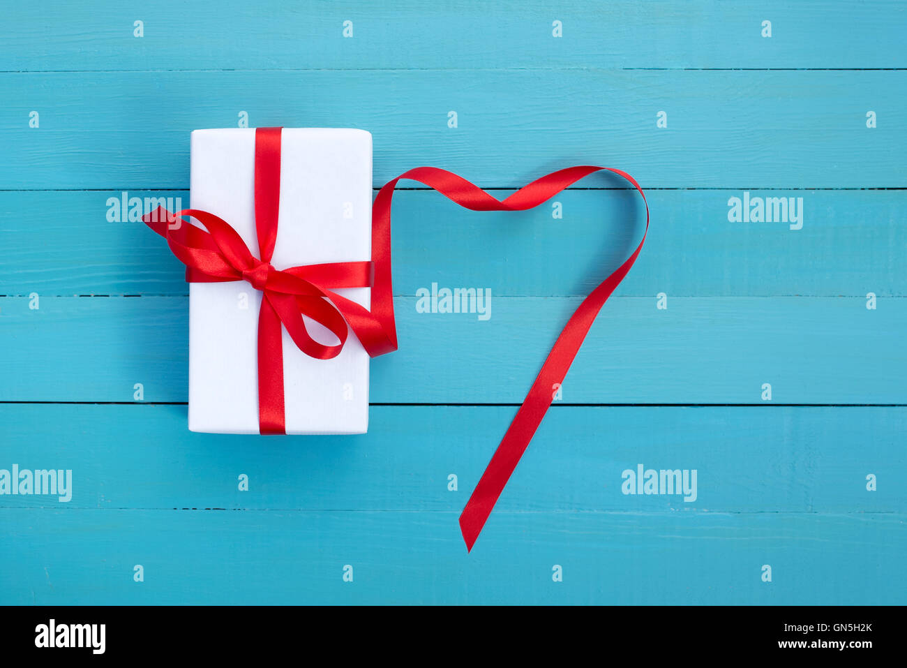gift in white packing with a red tape Stock Photo - Alamy