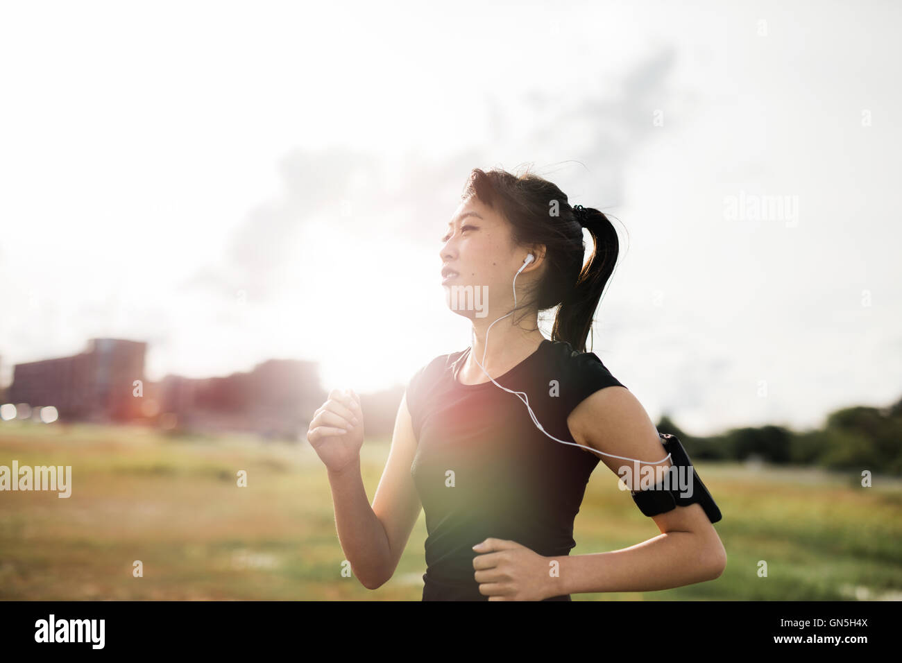 Outdoor shot of young fitness woman running in the park. Chinese female ...