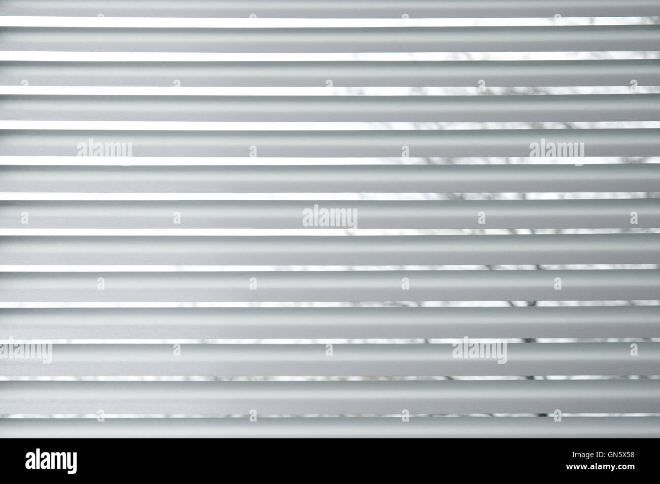 Semi-closed metallic blinds on a window Stock Photo - Alamy