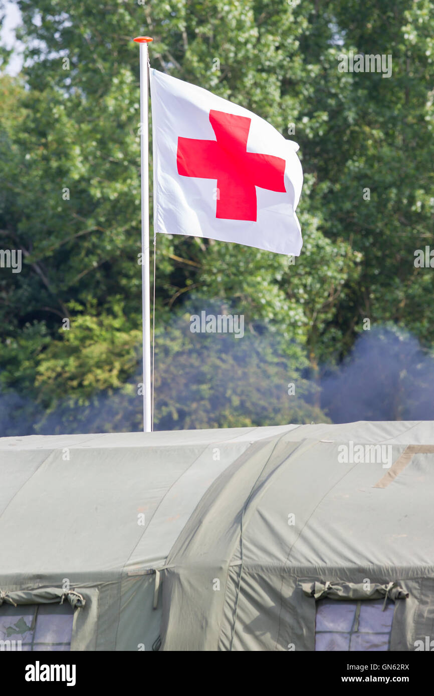 Red cross flag on top of an army tent Stock Photo - Alamy