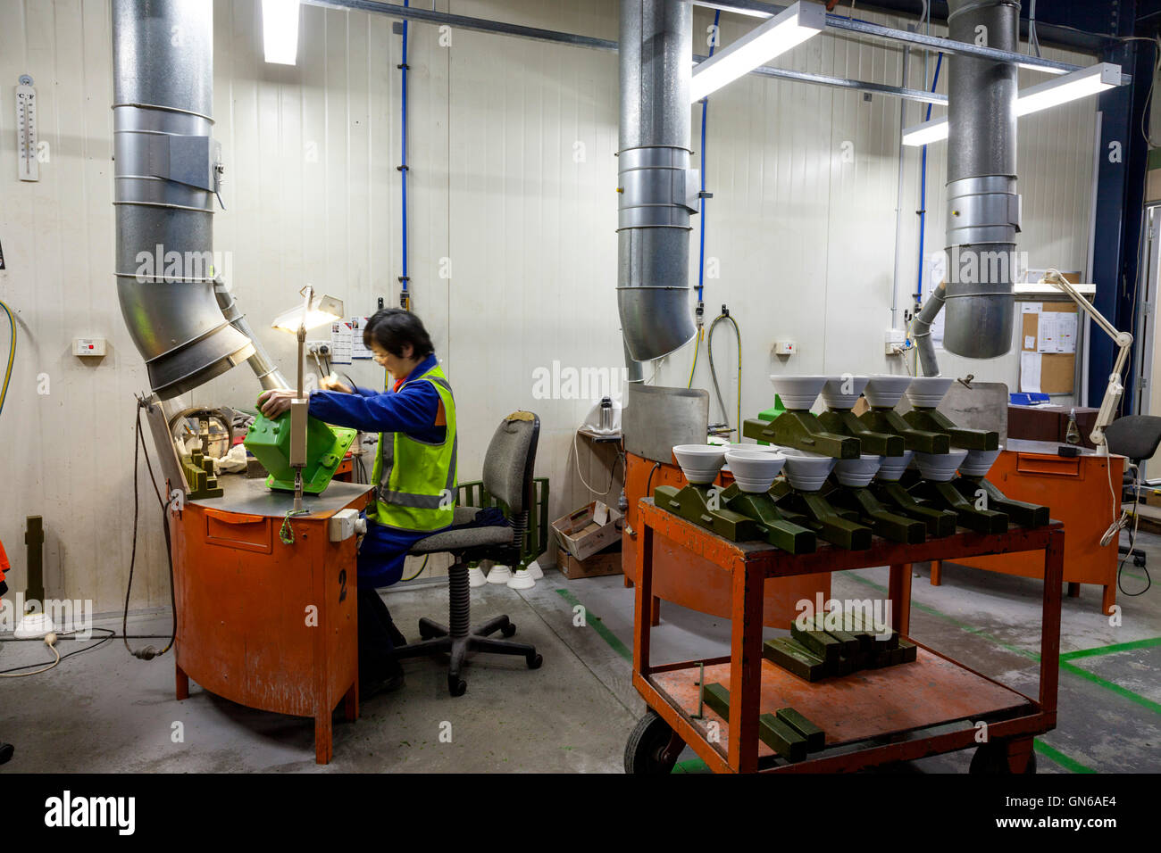 workmen finishing and polishing metal and plastic components ahead of ...