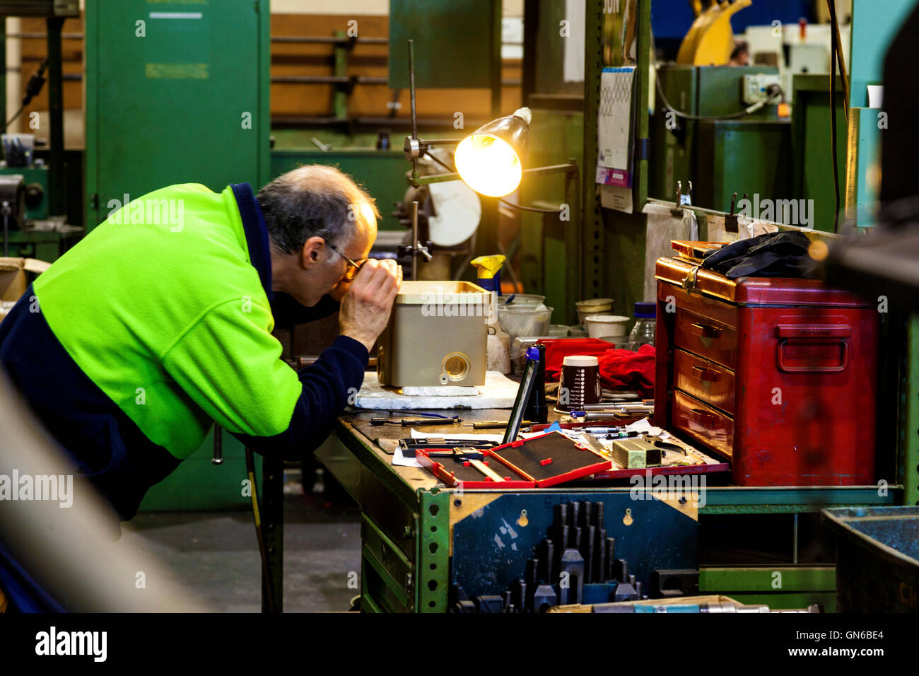 workmen finishing and polishing metal and plastic components ahead of ...