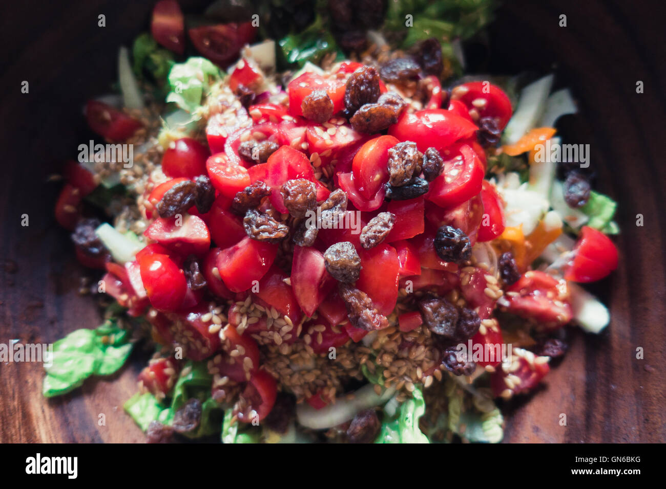 Summer salad with tomatoes seeds and sultana in a wood bowl Stock Photo ...