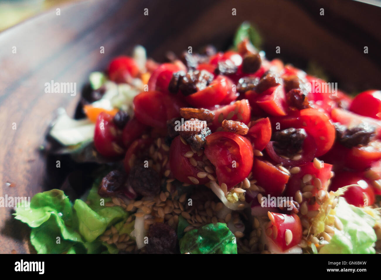 Summer salad with tomatoes seeds and sultana in a wood bowl Stock Photo ...