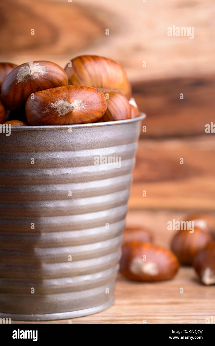 chestnuts in a tin bucket and chestnuts on wood Stock Photo - Alamy