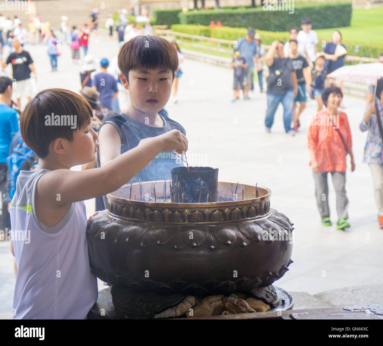 Boys lighting an incense stick Stock Photo - Alamy
