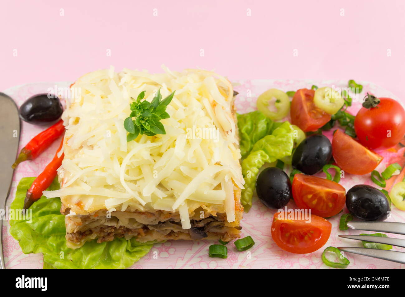 Lasagna portion served with fresh vegetables on a plate Stock Photo - Alamy