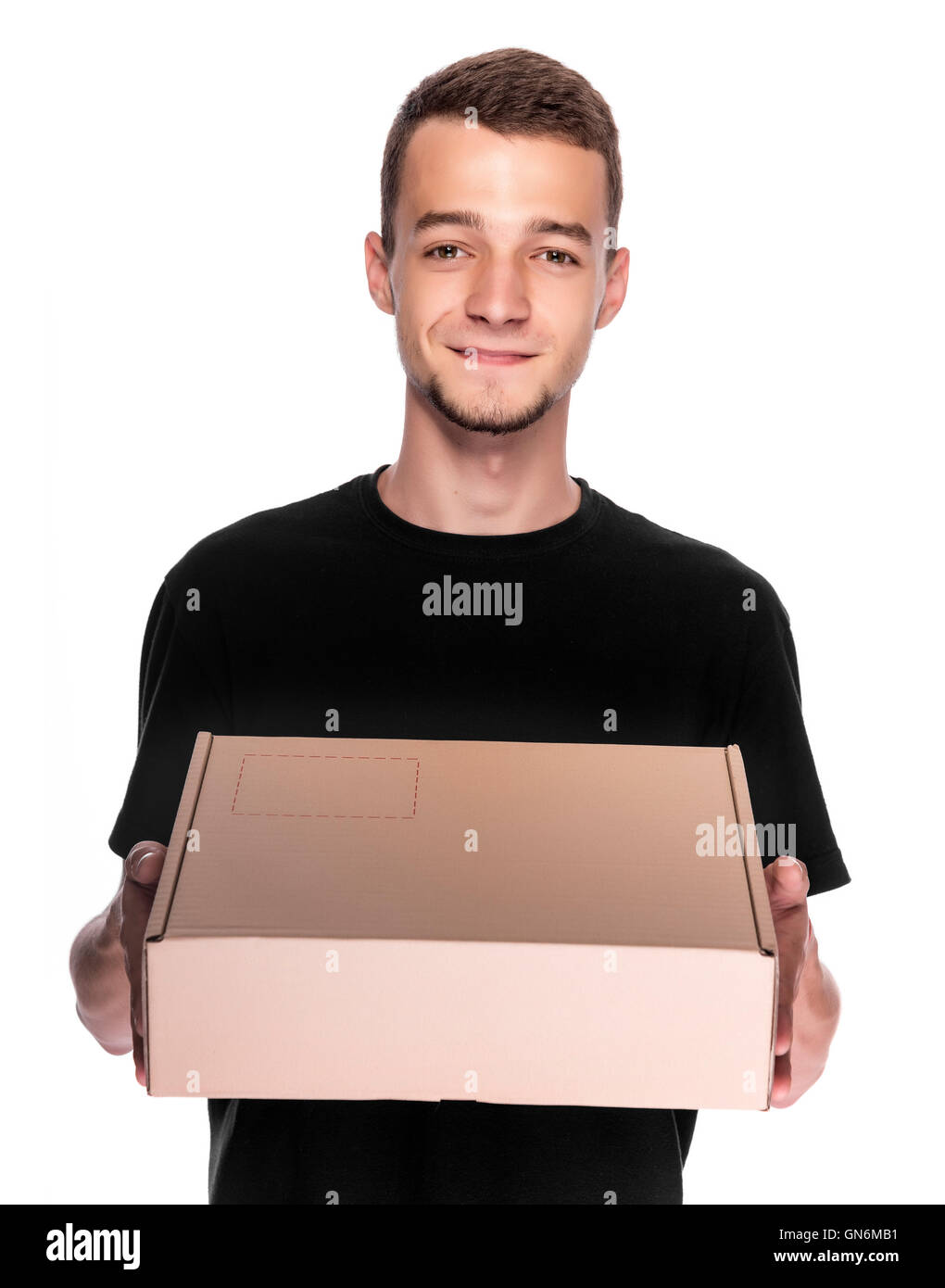Smiling young delivery man holding and carrying a cardbox isolated on ...