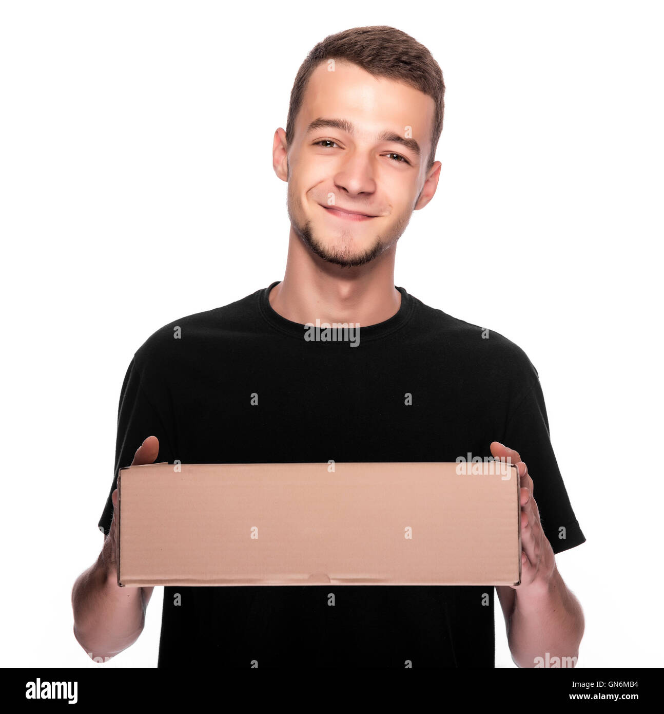 Smiling young delivery man holding and carrying a cardbox isolated on ...