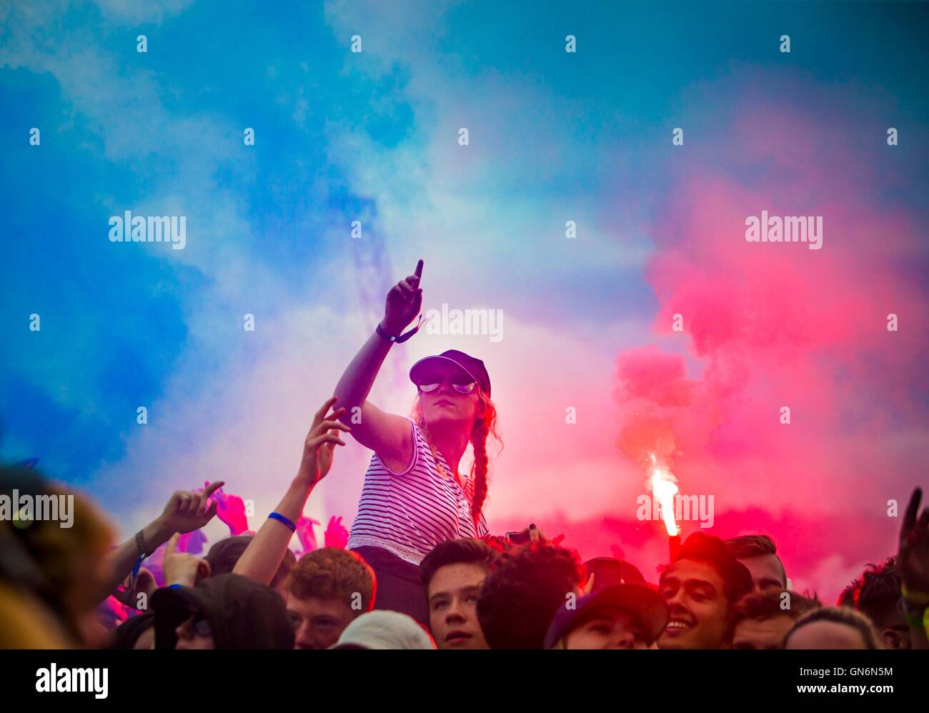 Coloured smoke flares are set off by festival-goers during a ...