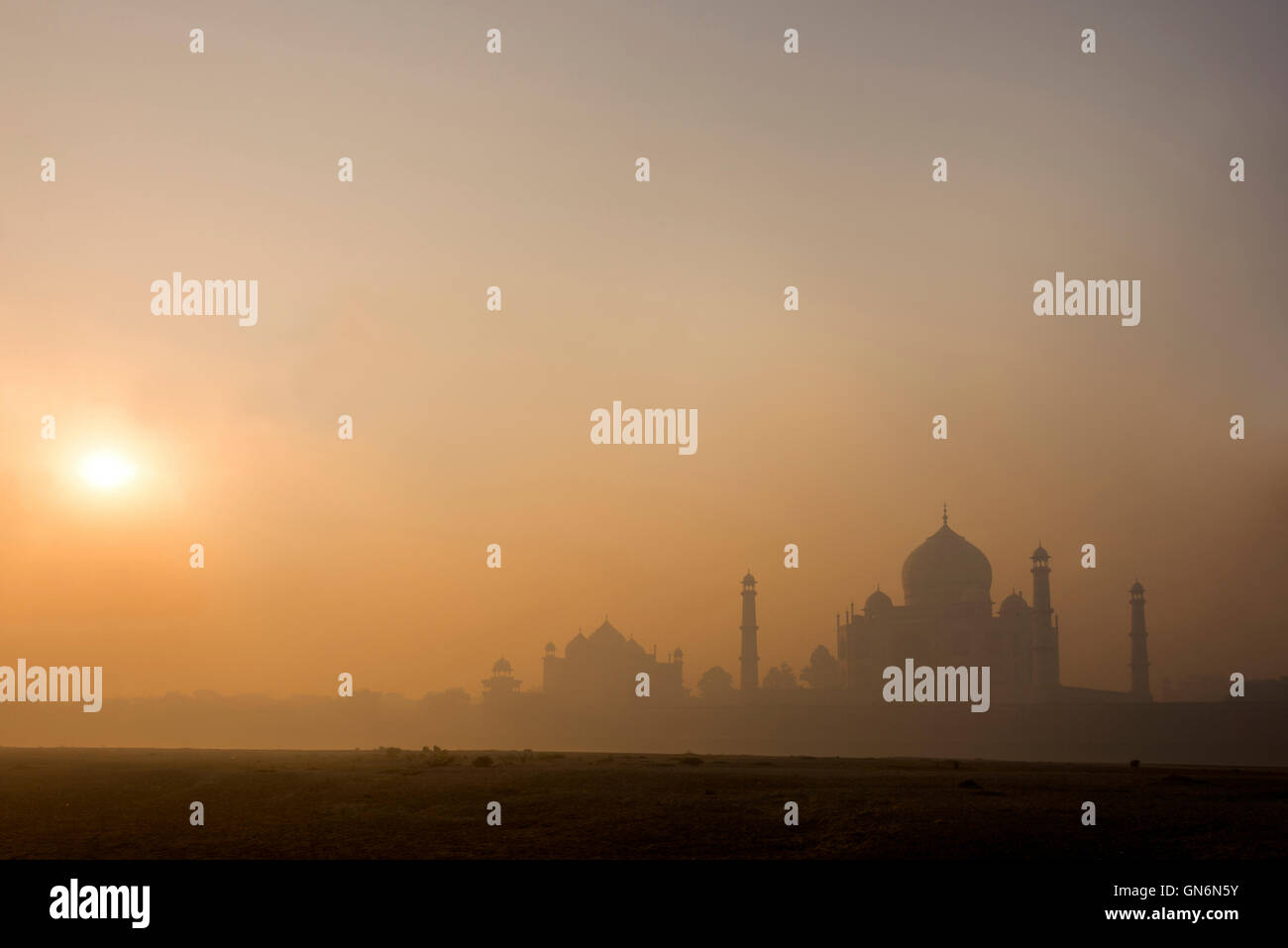 The rising sun in the early morning mist over the Taj Mahal in Agra ...