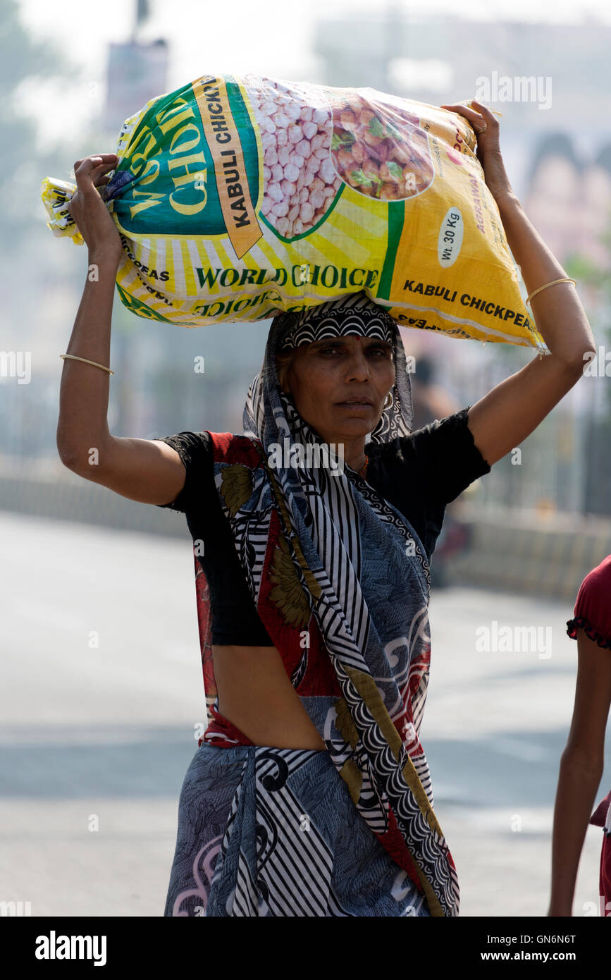 Indian woman carrying a sack on her head hi-res stock photography and ...