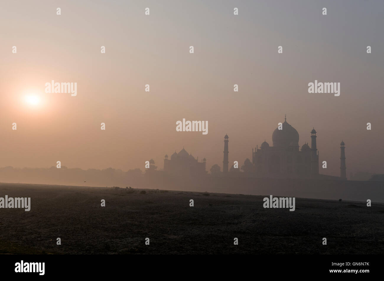 The rising sun in the early morning mist over the Taj Mahal in Agra ...