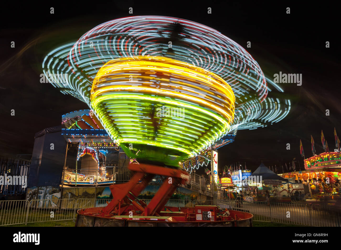 Colorfully illuminated rides spin against the night sky during the New ...