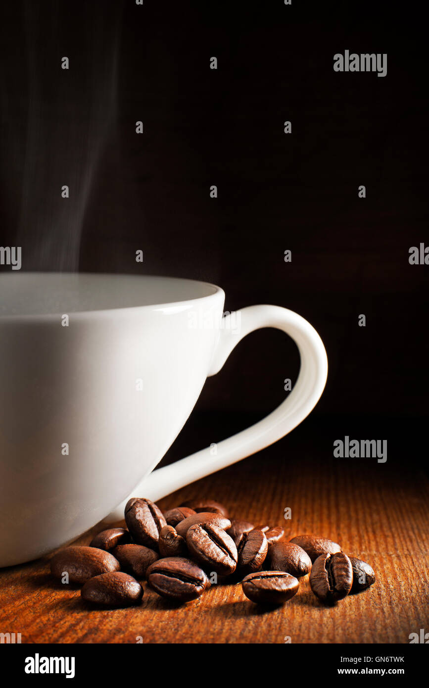 Coffee cup and beans on a wooden background Stock Photo - Alamy
