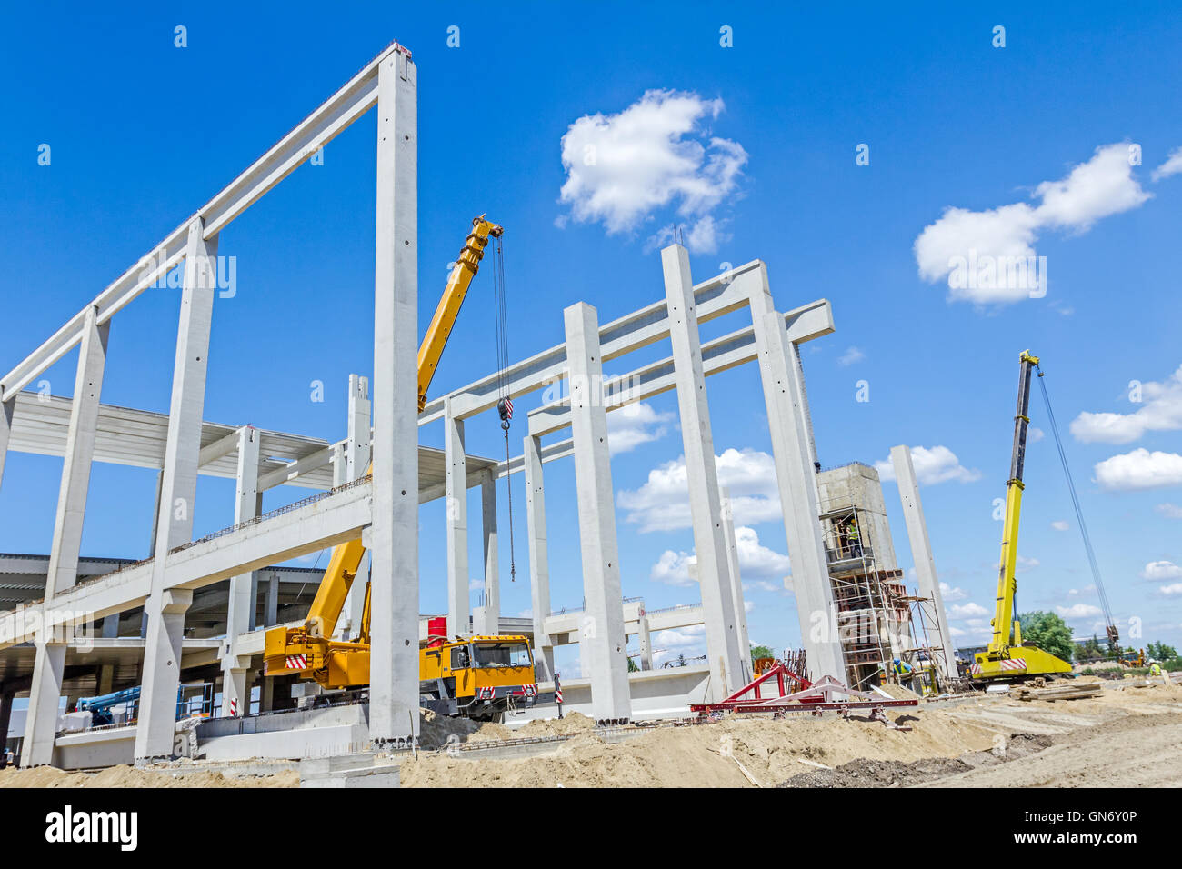 Mobile crane is working to assembly huge hall. Placing the truss on ...