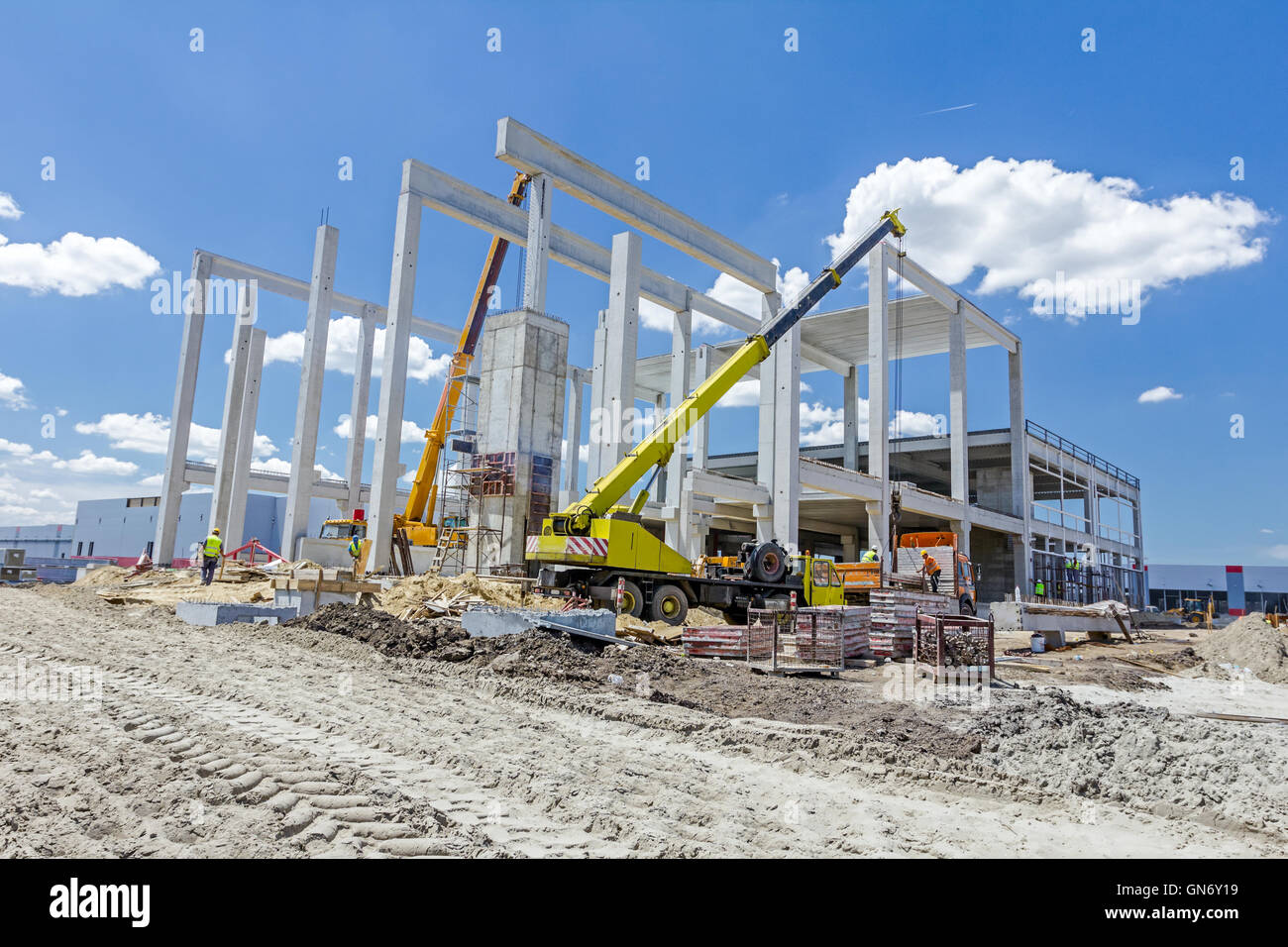 Mobile crane is working to assembly huge hall. Placing the truss on ...