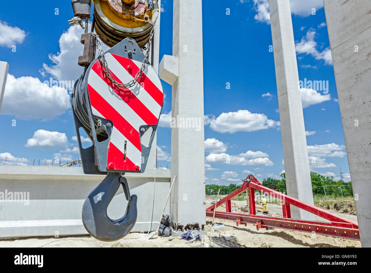Big crane hook with red stripes is hanging, building site in background ...