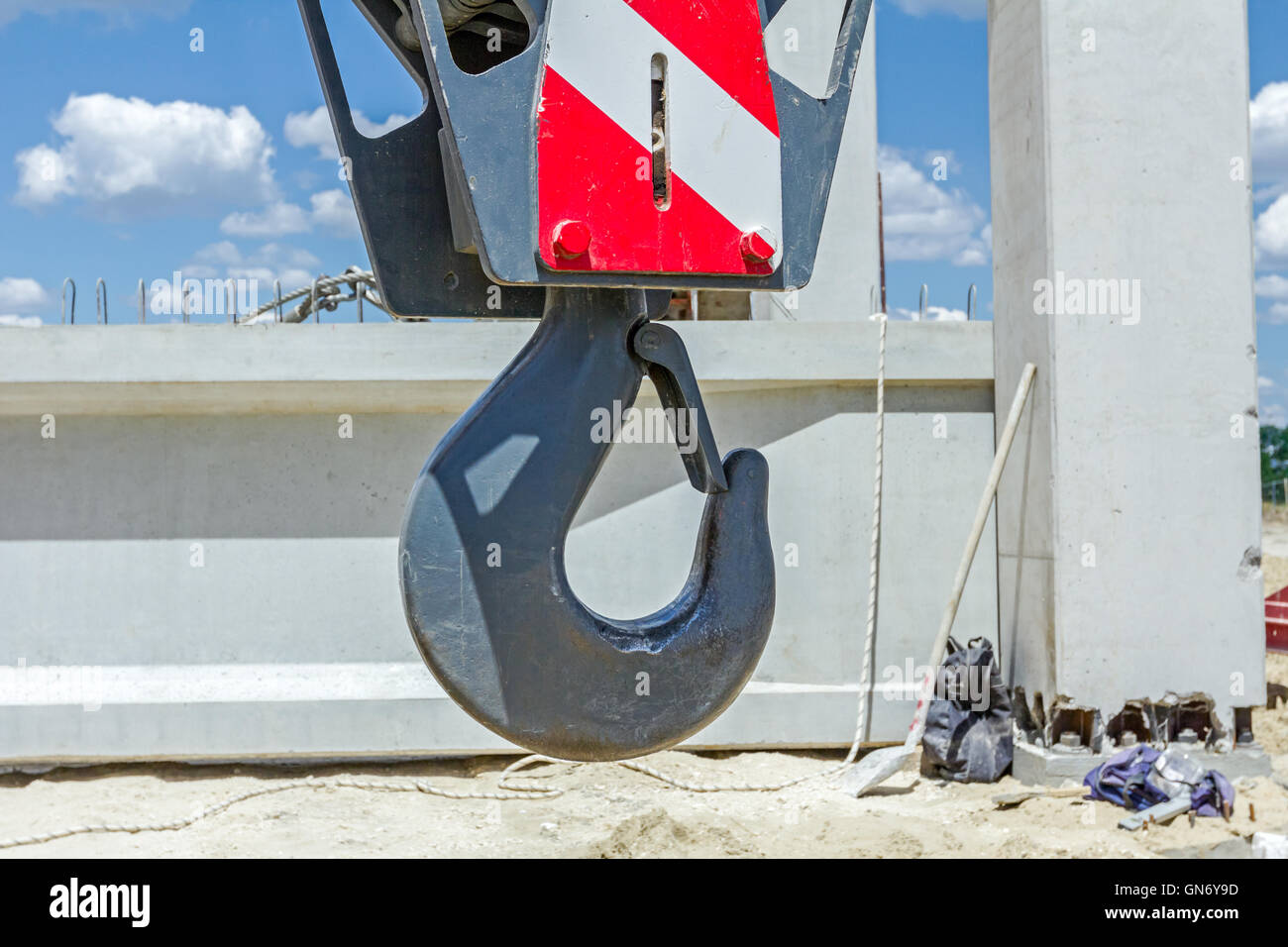 Big crane hook with red stripes is hanging, building site in background ...