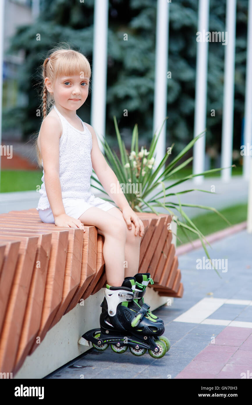 Little girl rides on roller skates at park Stock Photo - Alamy