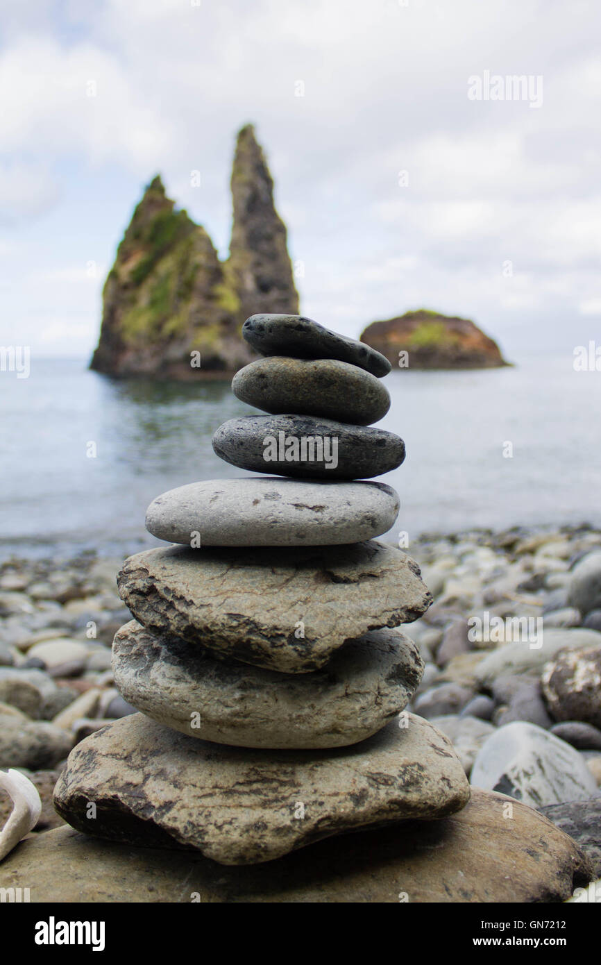 A set of rocks pilled on each other with two little island displayed in ...