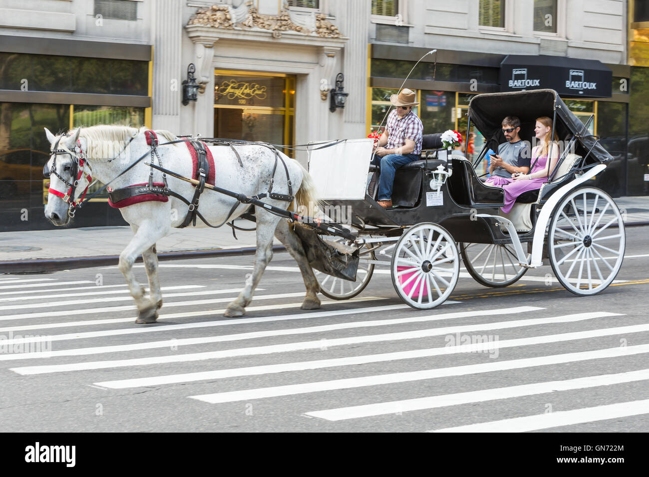 A couple takes a horse-drawn carriage ride in New York City Stock Photo ...
