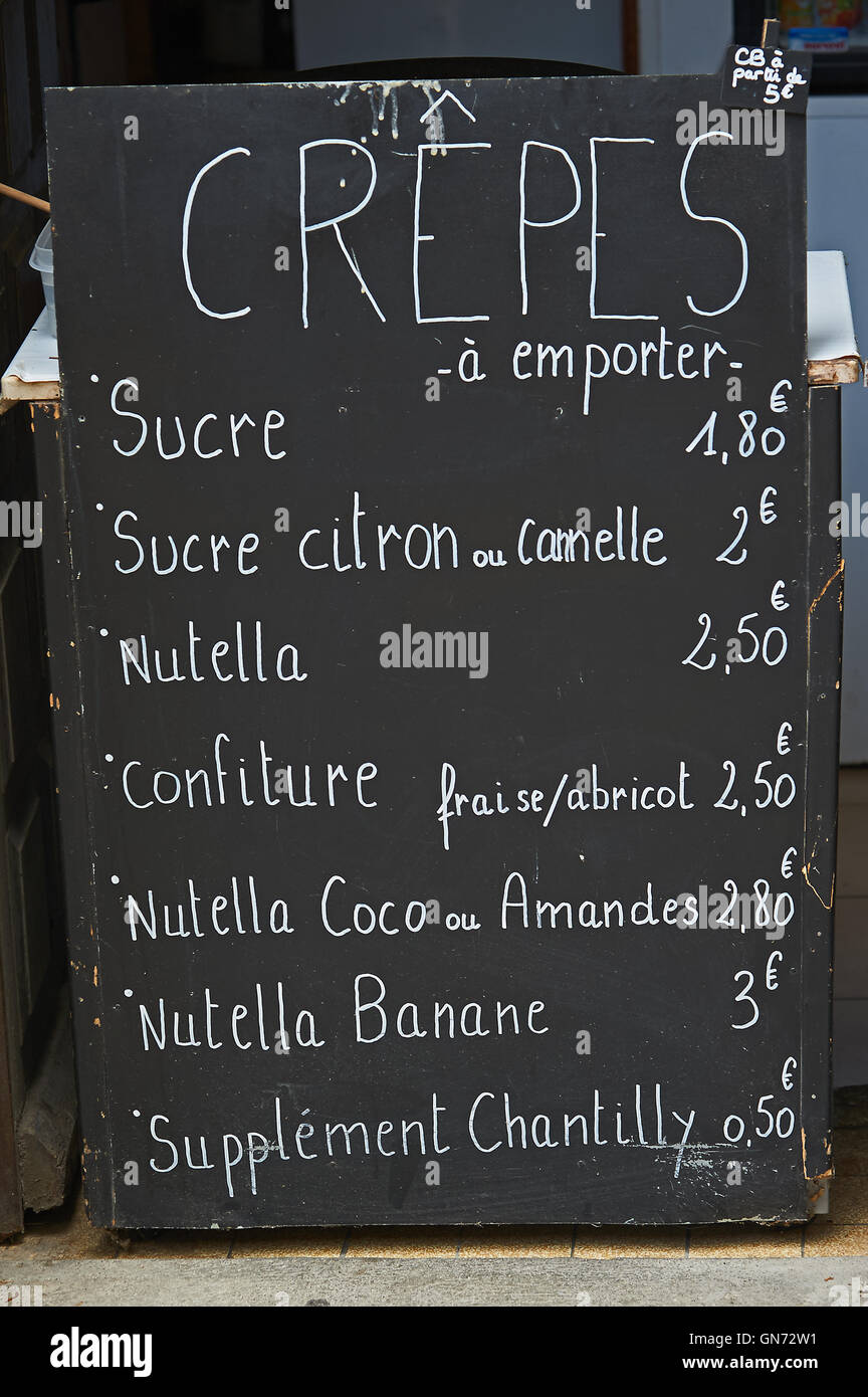 Chalkboard sign outside a shop advertising different flavours of crepes ...