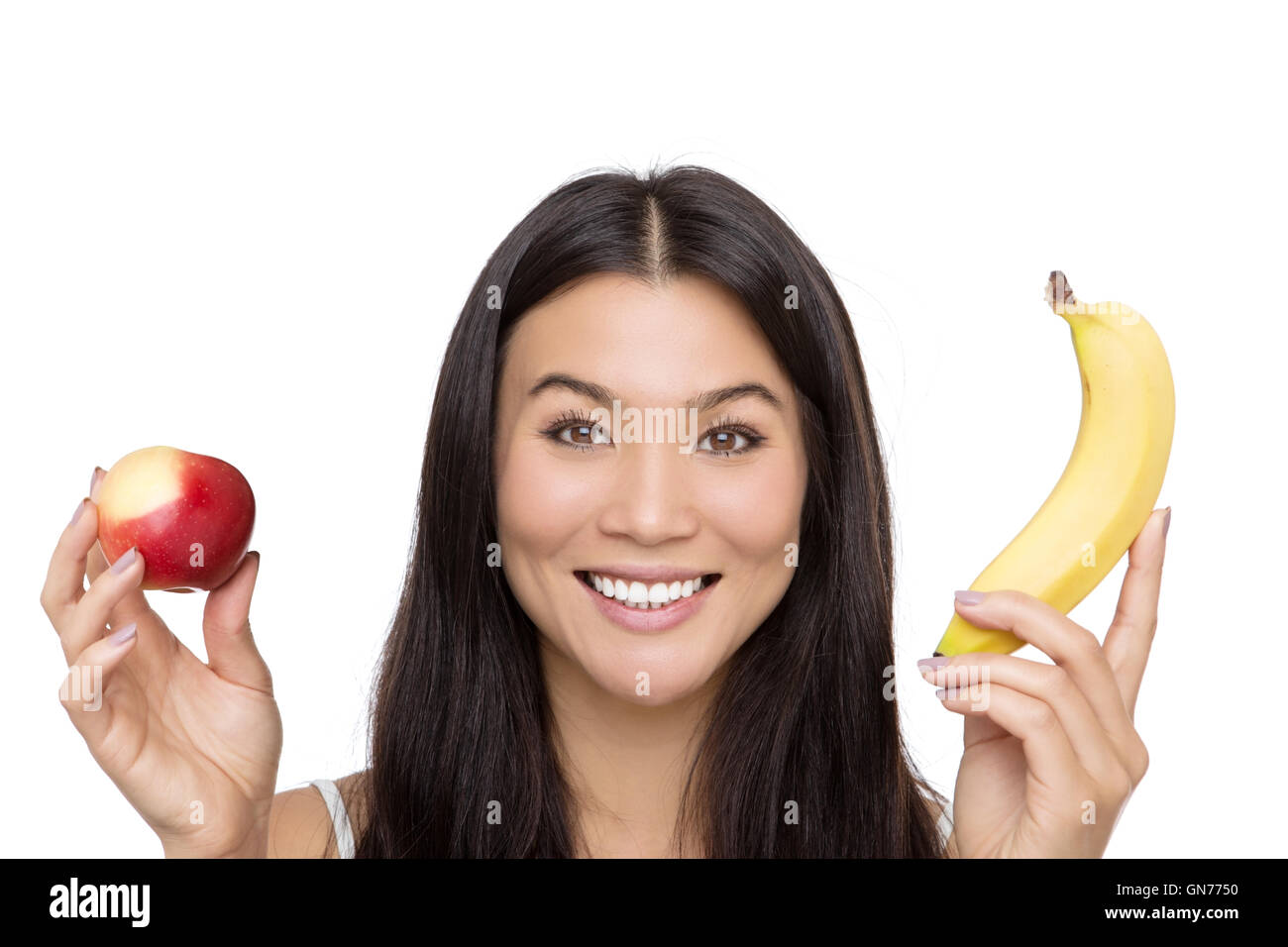 woman holding fruit and veg up shot in the studio on a white background ...