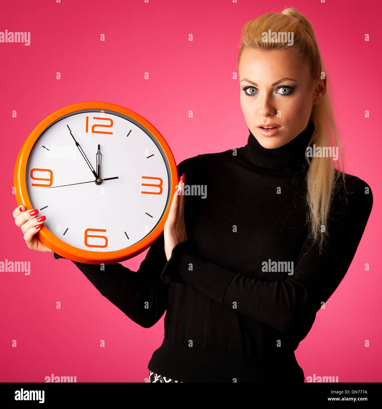 Worried woman with big orange clock gesturing delay, rush, nervous ...