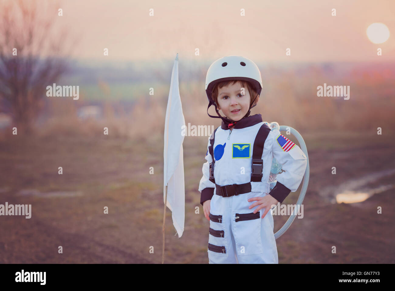 Adorable little boy, dressed as astronaut, playing in the park with ...