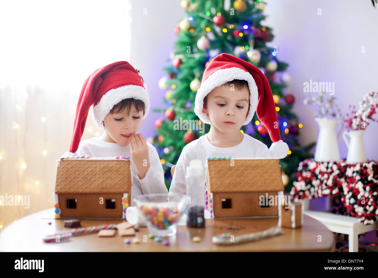 Two sweet boys, brothers, making gingerbread cookies house, decorating ...