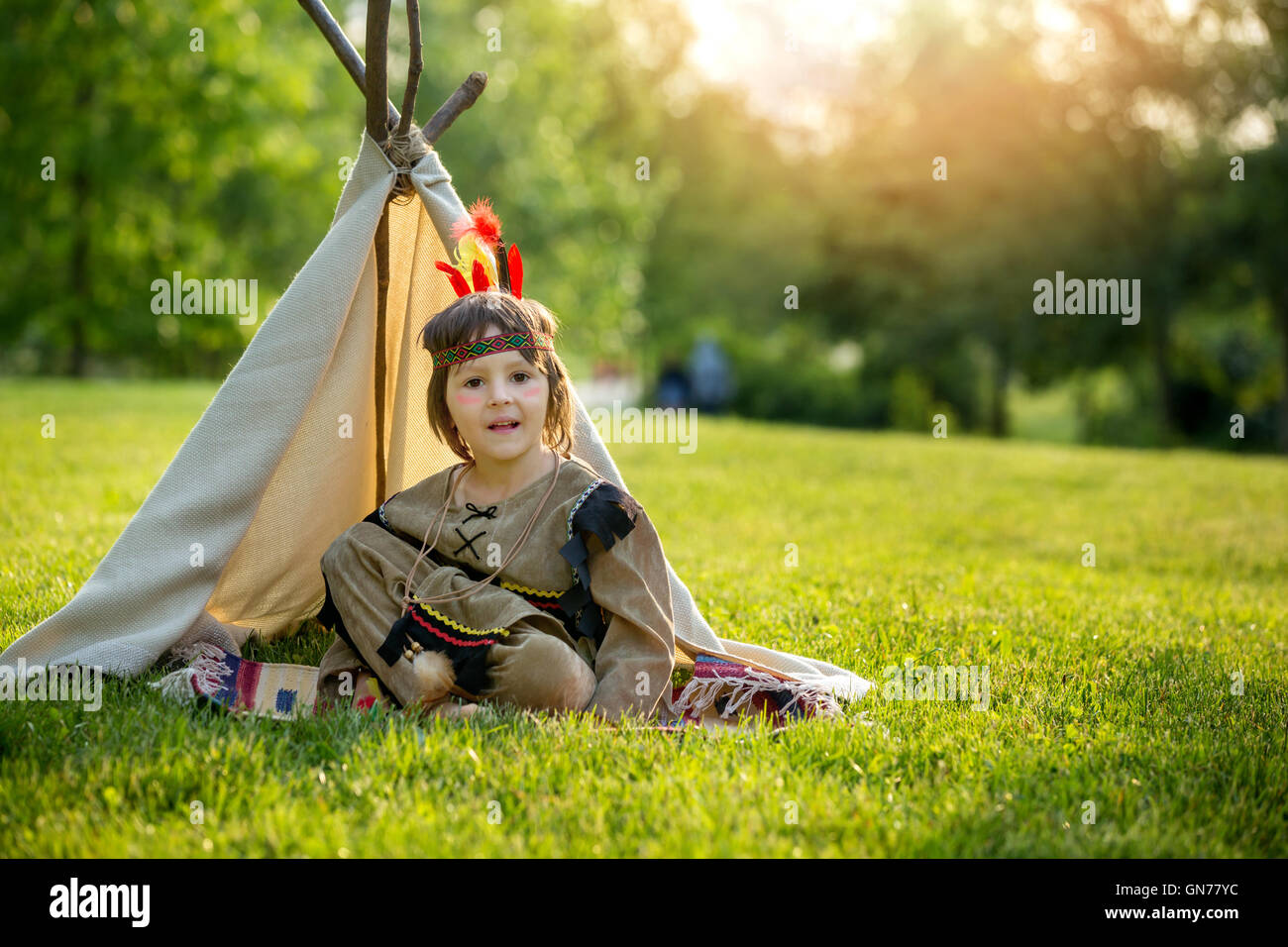 Cute portrait of native american boy with costumes, playing outdoor in ...