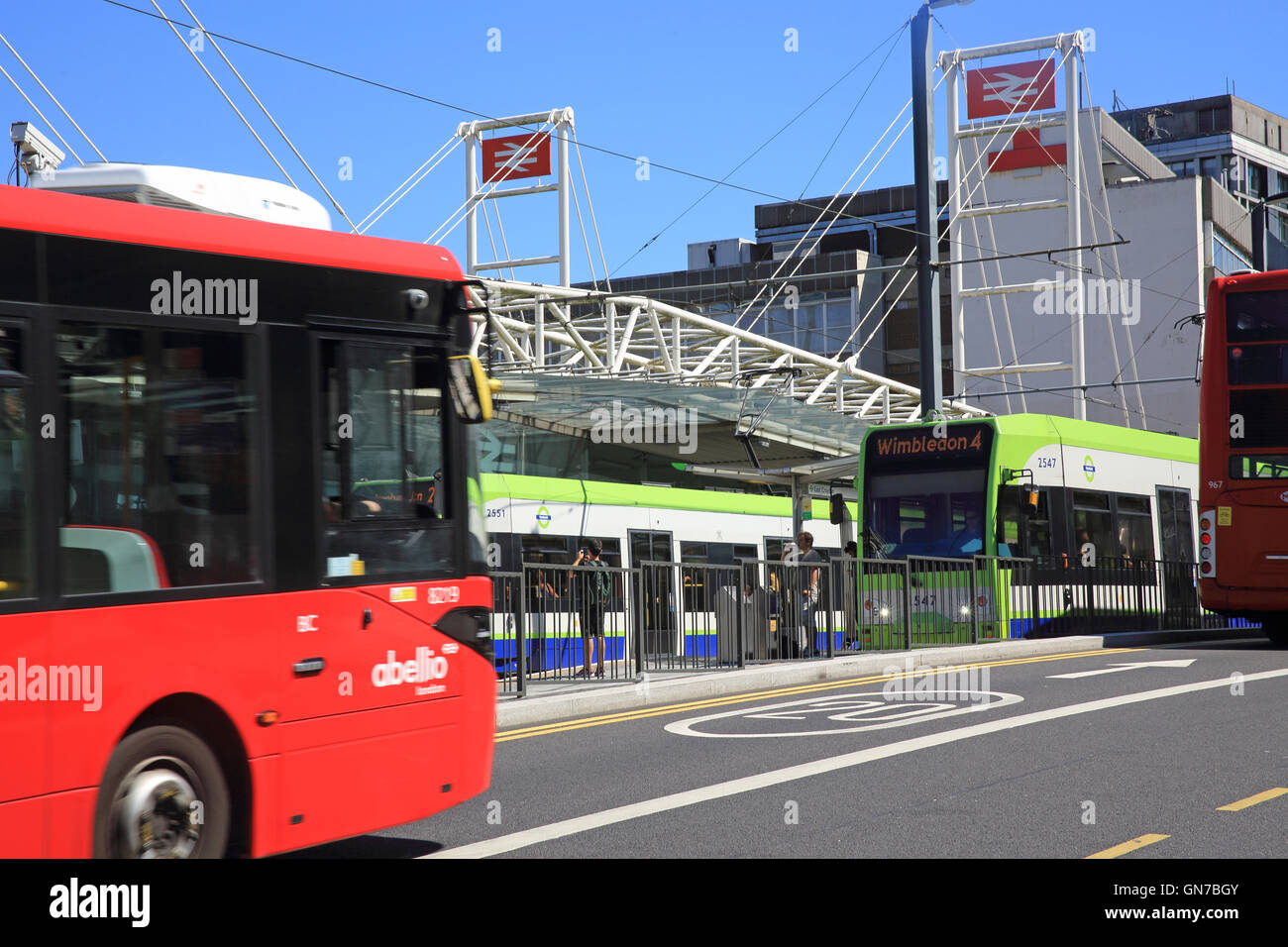 Trams and buses in front of busy East Croydon train station, in south ...