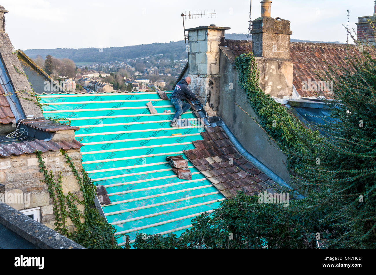 A roofer at work on listed house in Batheaston, Bath, Somerset, England ...