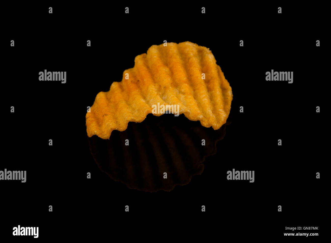 Potato chip on black surface closeup reflection detail Stock Photo - Alamy