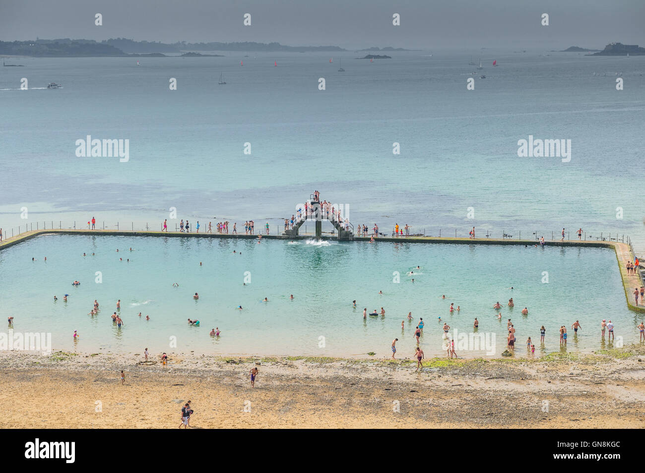 Swimmers enjoying the outdoor swimming pool on the beach at St. Malo ...