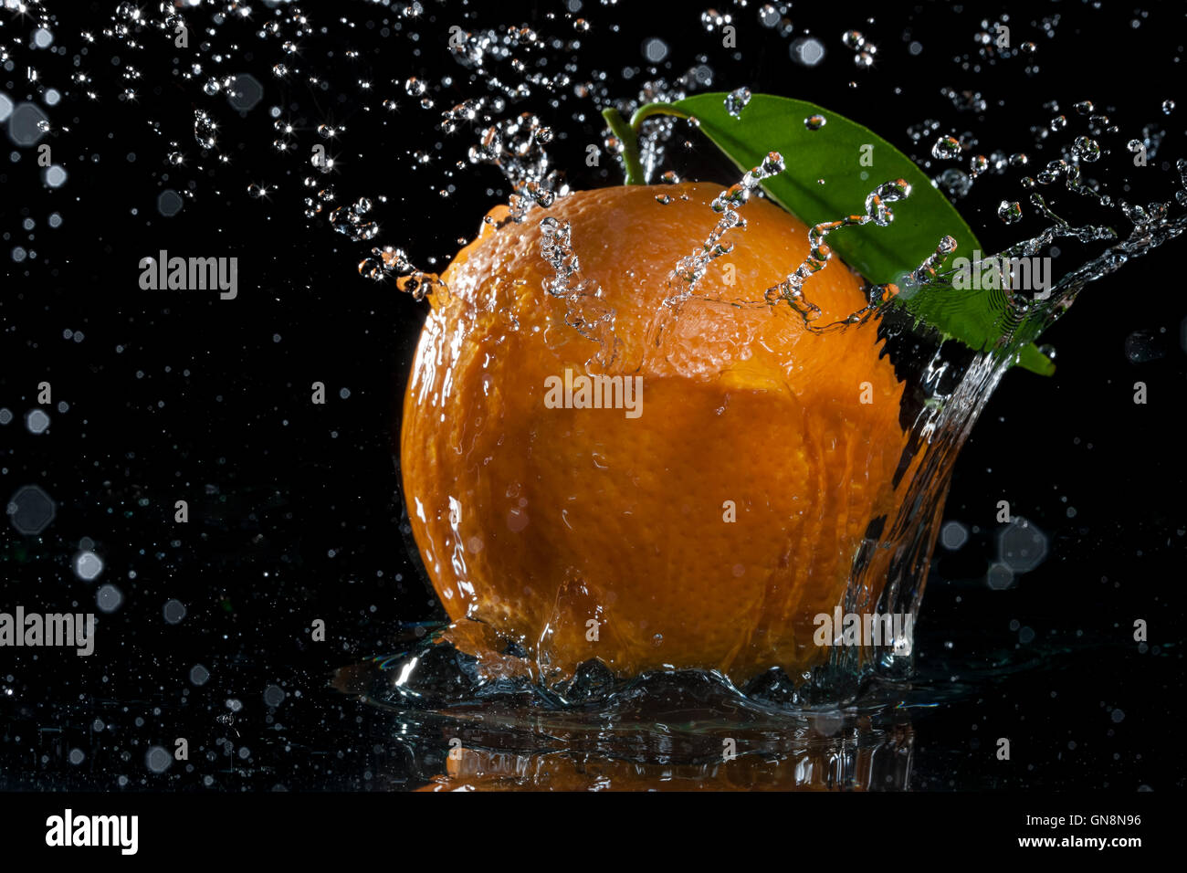 Ripe orange in a spray against a black background. A series of fruits ...
