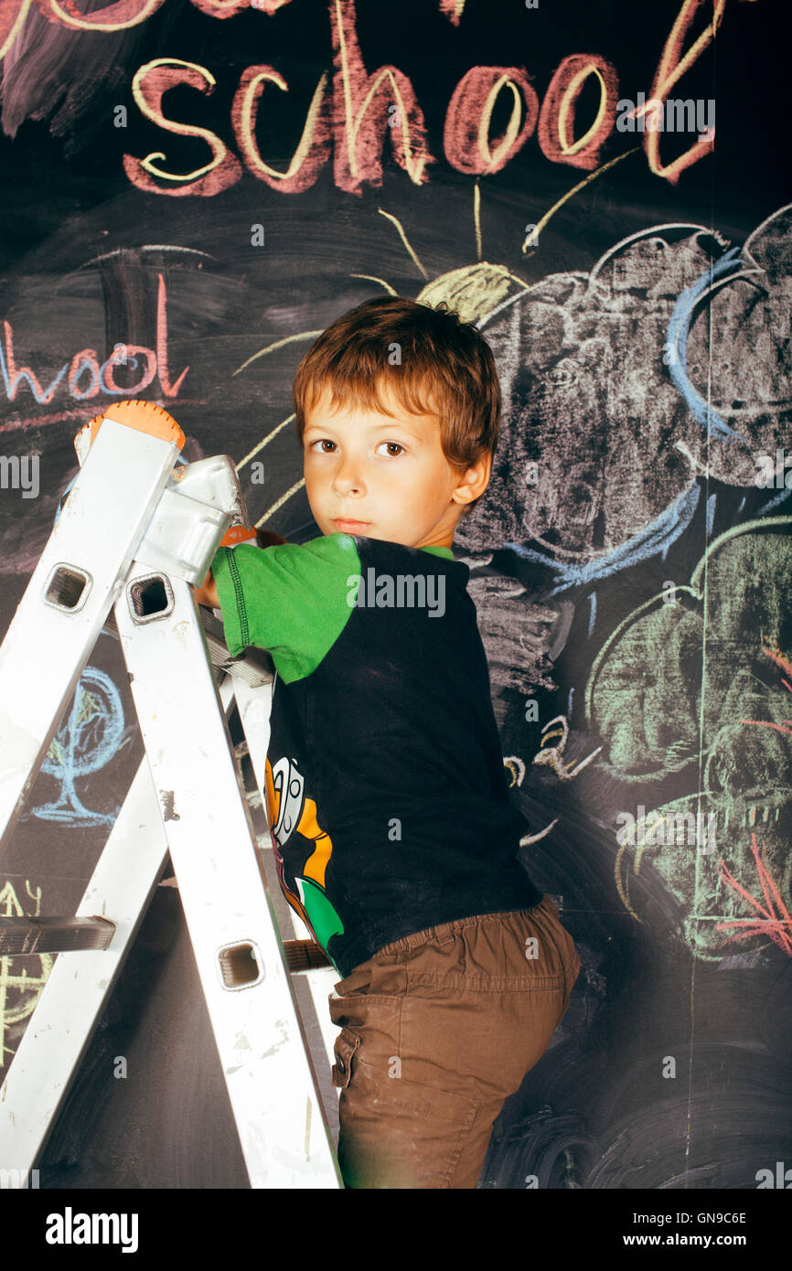 little cute real boy at blackboard in classroom, back to school close ...