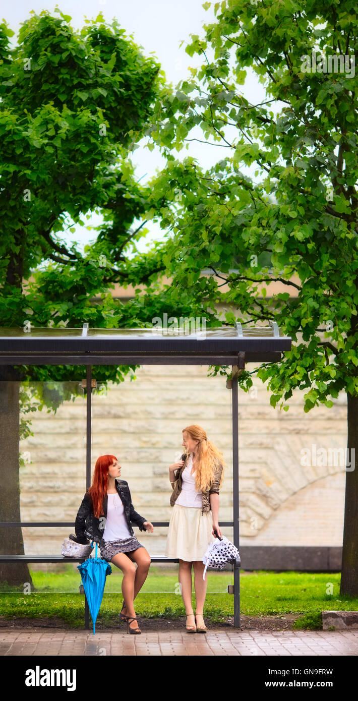 Two Girls at Bus Stop Stock Photo - Alamy