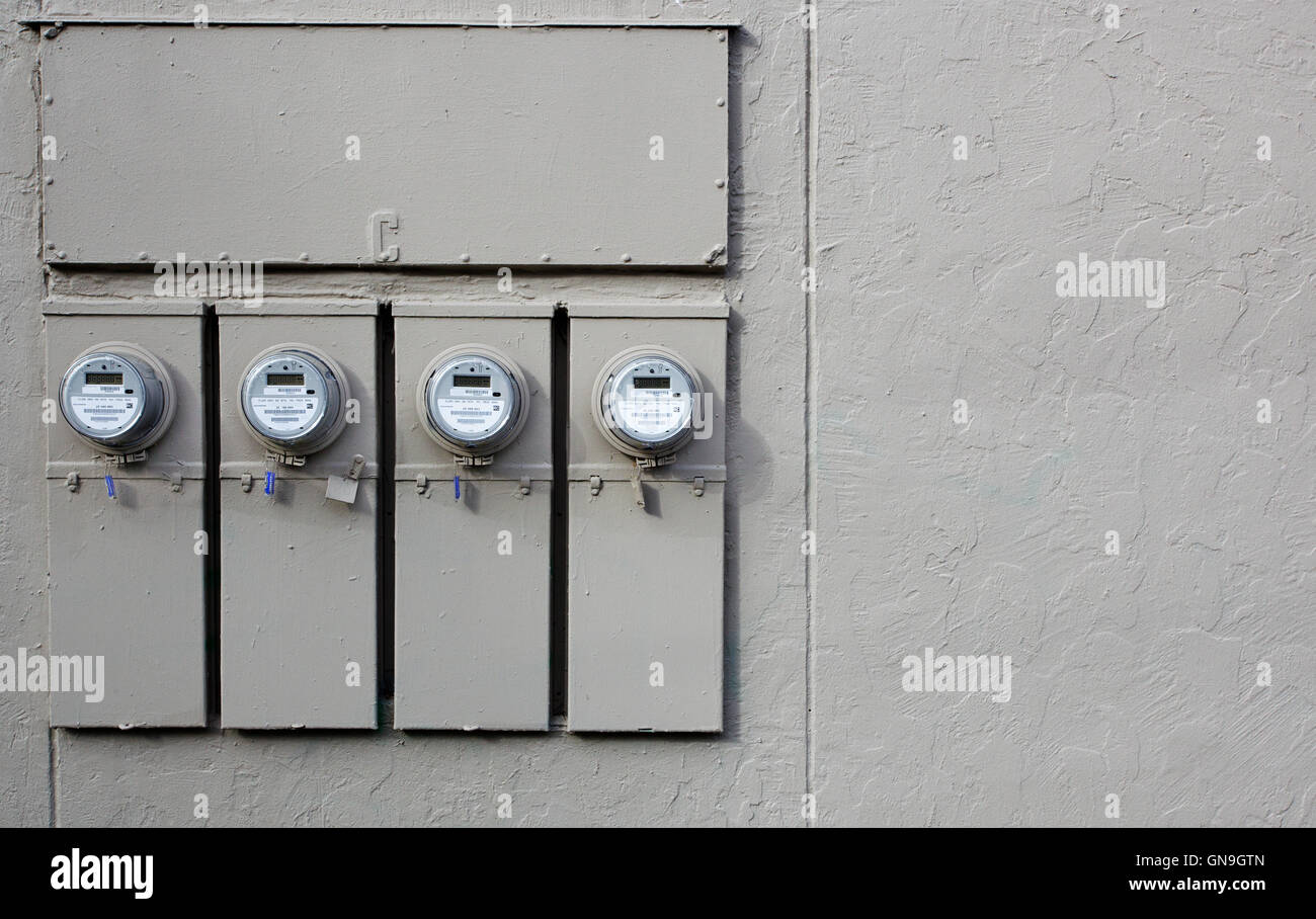 Four Electric Meters gray wall Stock Photo - Alamy