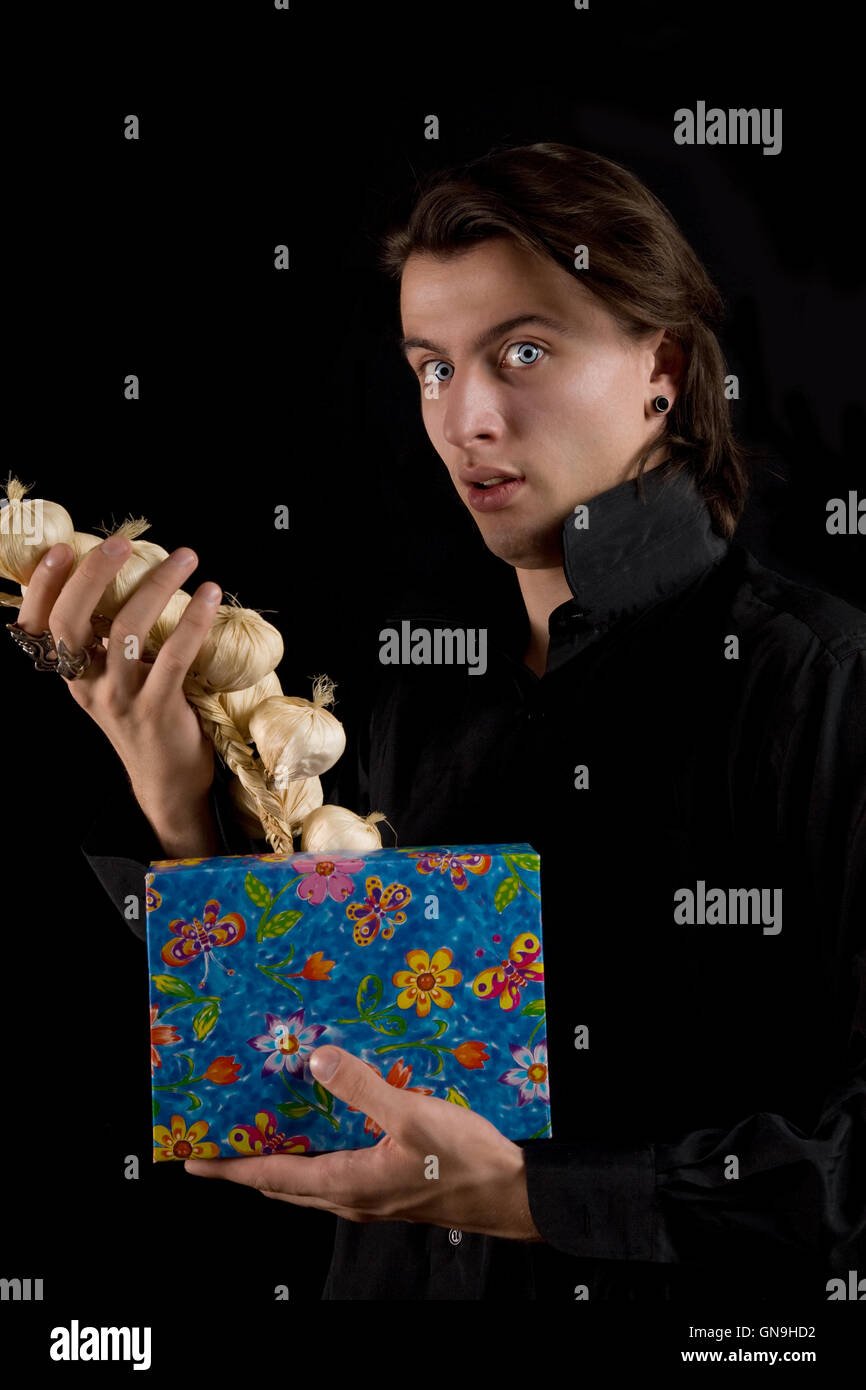 Funny vampire with gift box taking out garlic Stock Photo - Alamy