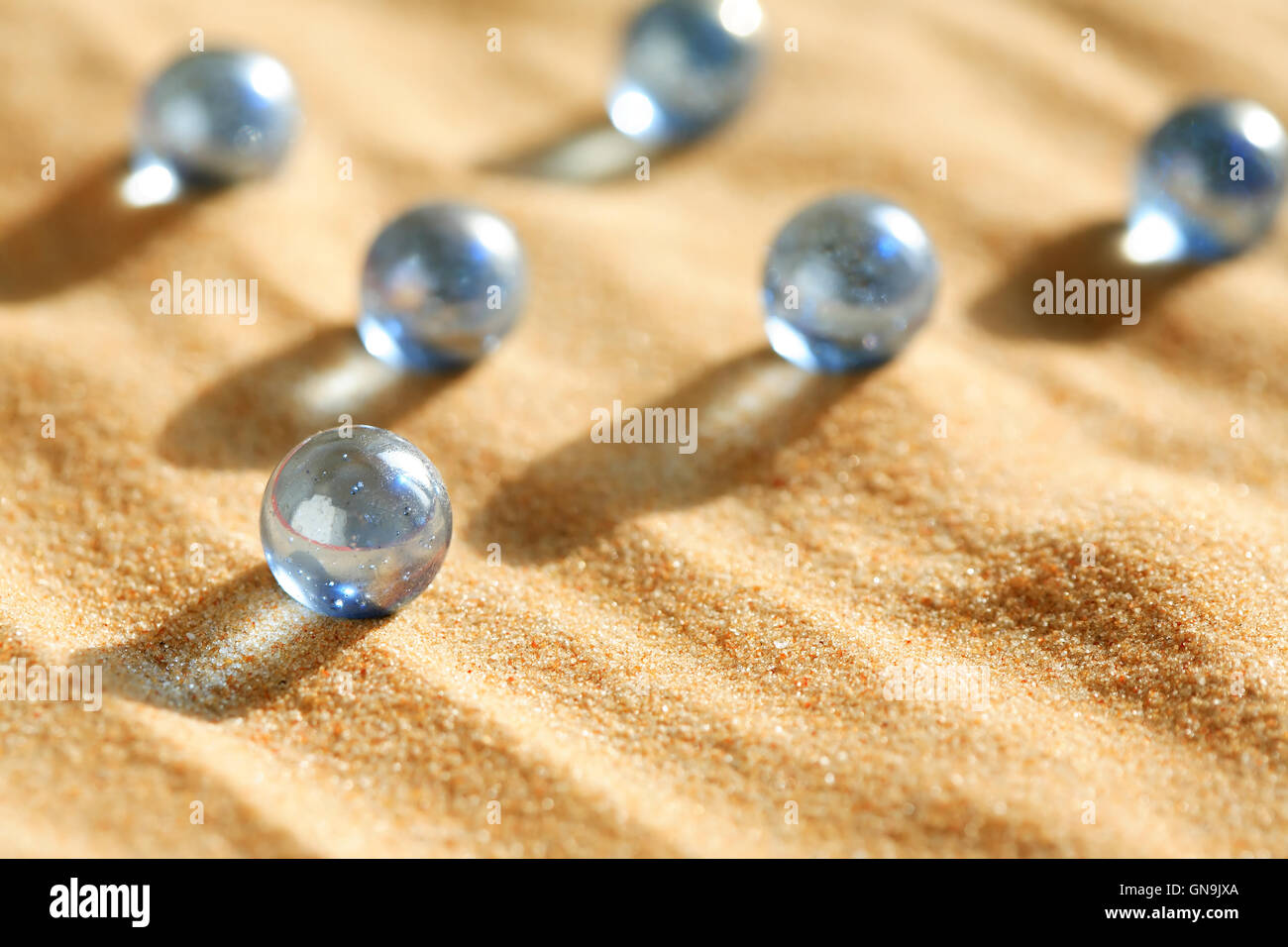 Glass Balls In Sand Stock Photo - Alamy