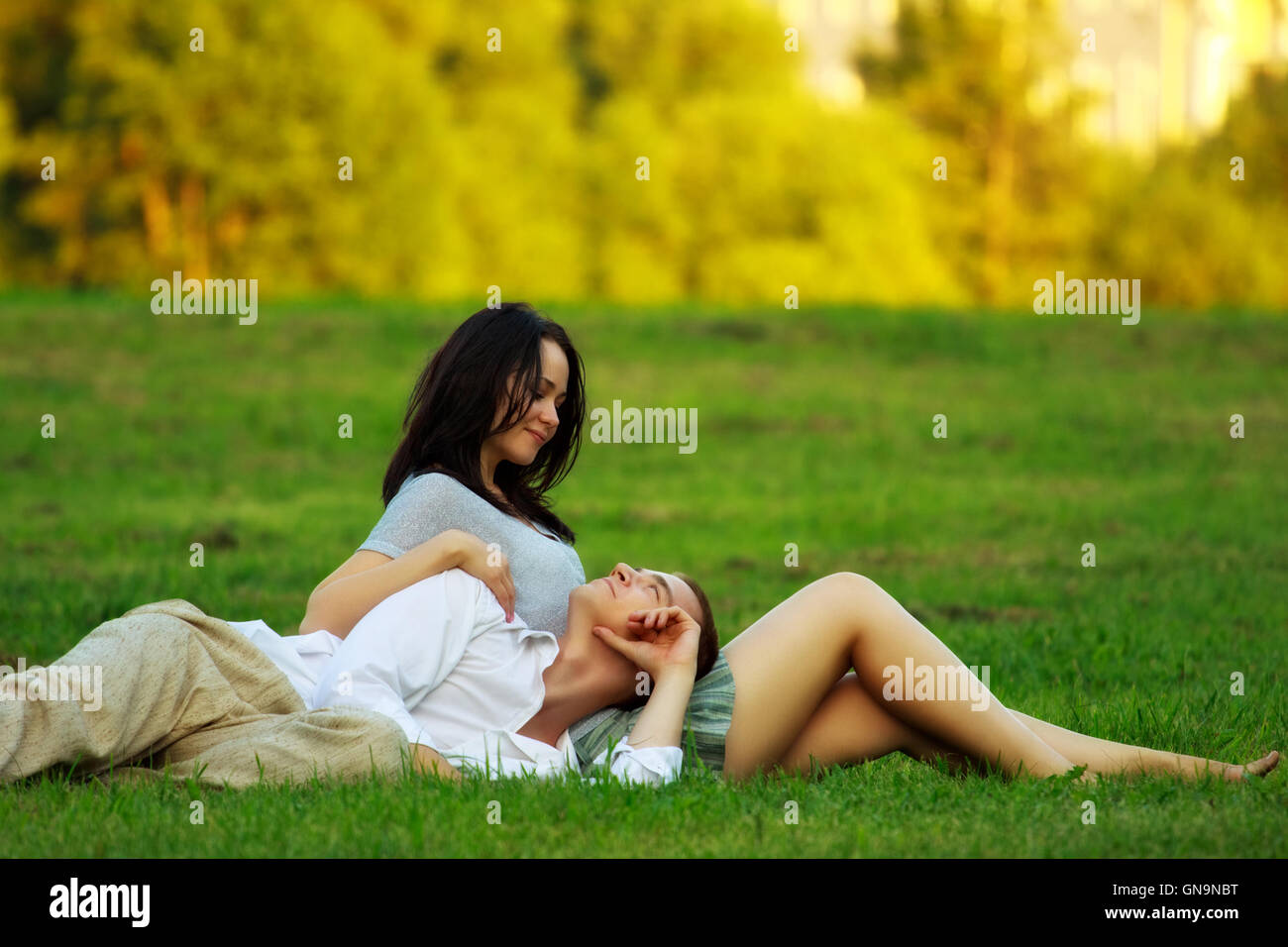 couple laying on park lawn Stock Photo - Alamy