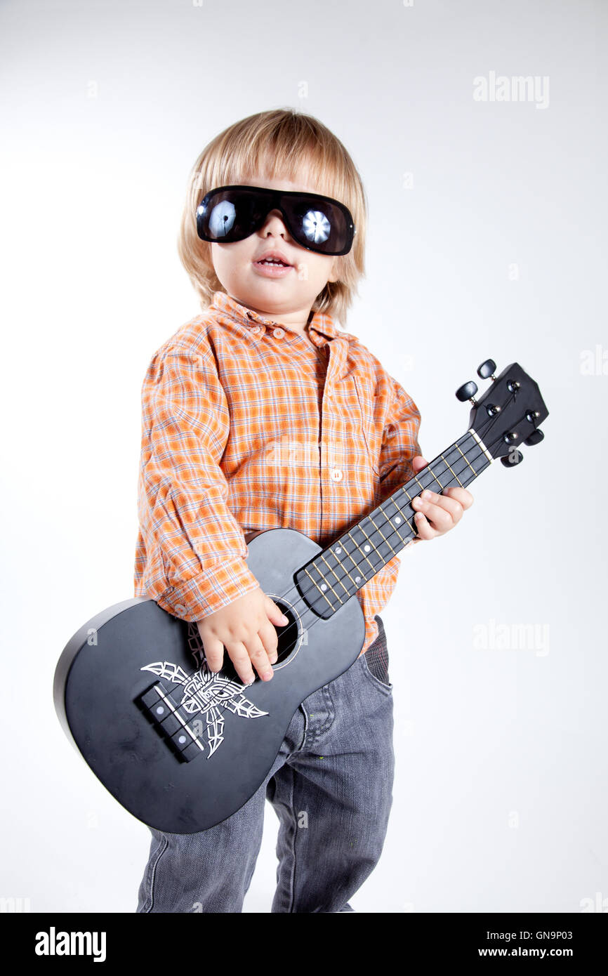Cute little boy with ukulele guitar Stock Photo - Alamy