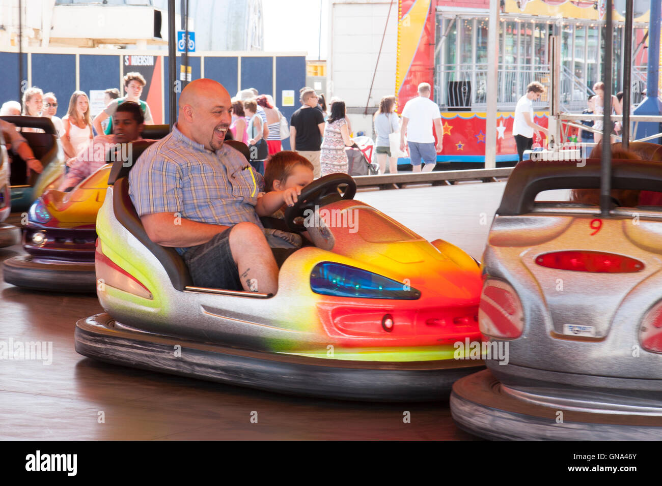 England, Ramsgate. Bumper cars, dodgems. Mature overweight man with ...