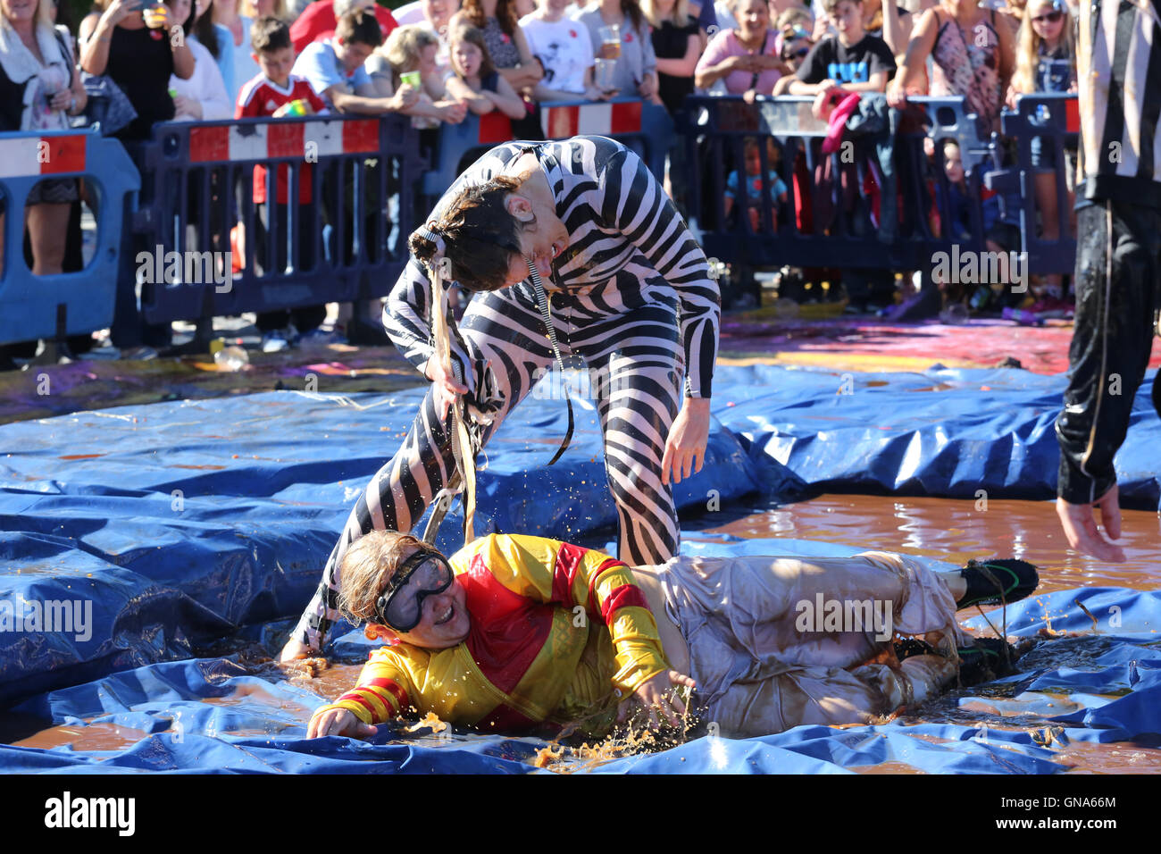 A women wresler in a zebra patterned costume standing over her opponent ...